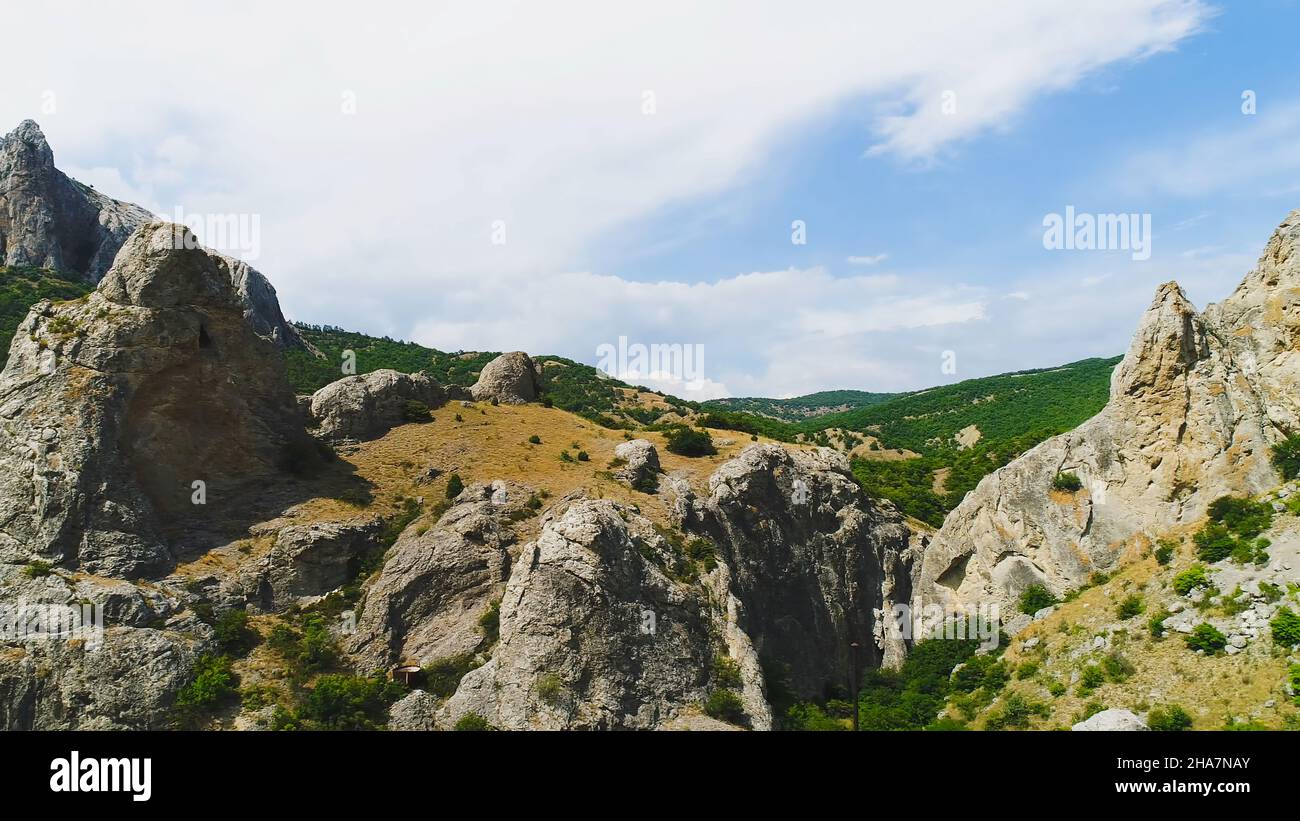Top view of rock ridges on the background of green mountains and blue ...