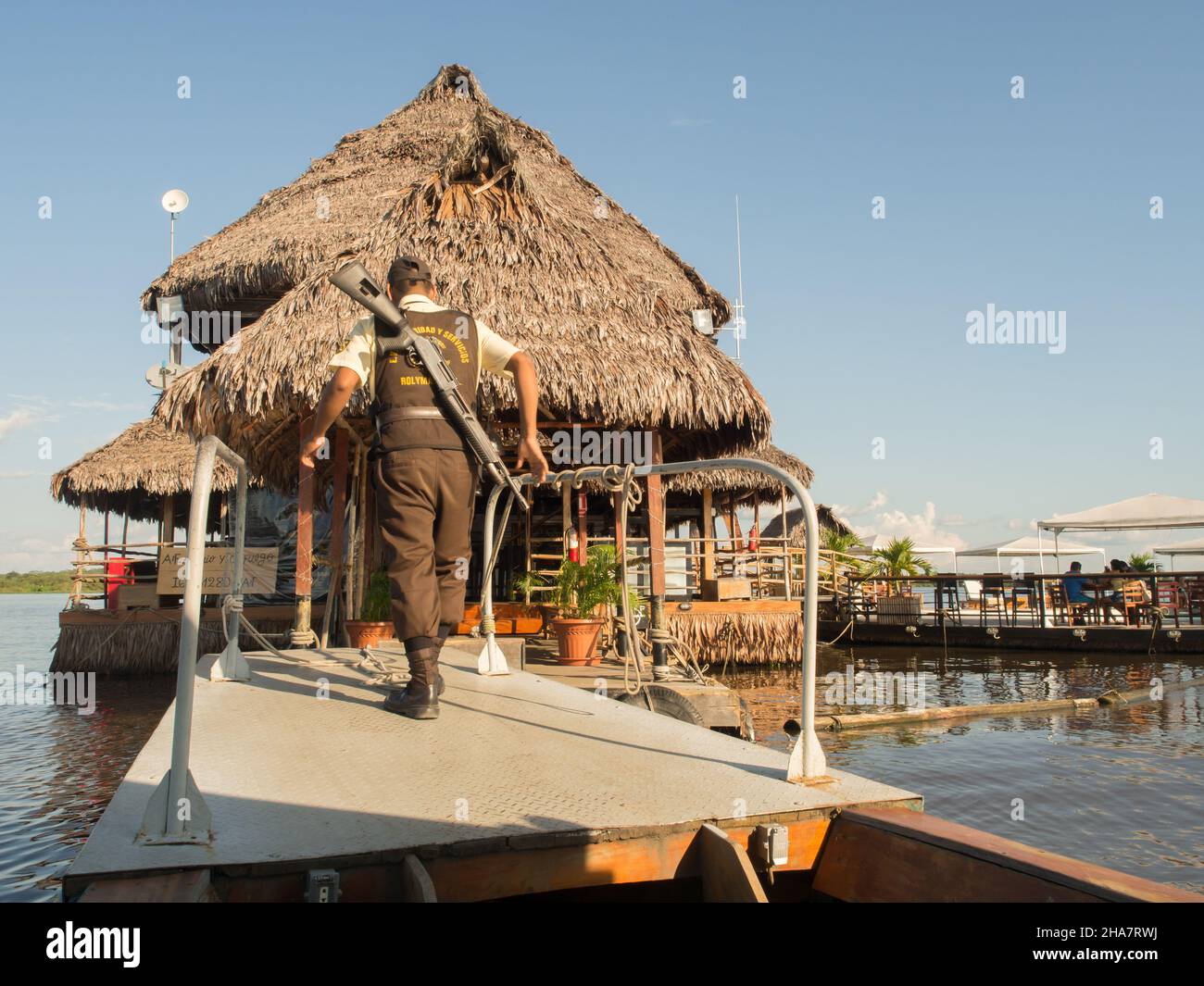 Iquitos, Peru - December 2017: Bodyguard with a gun on a boat going to ...