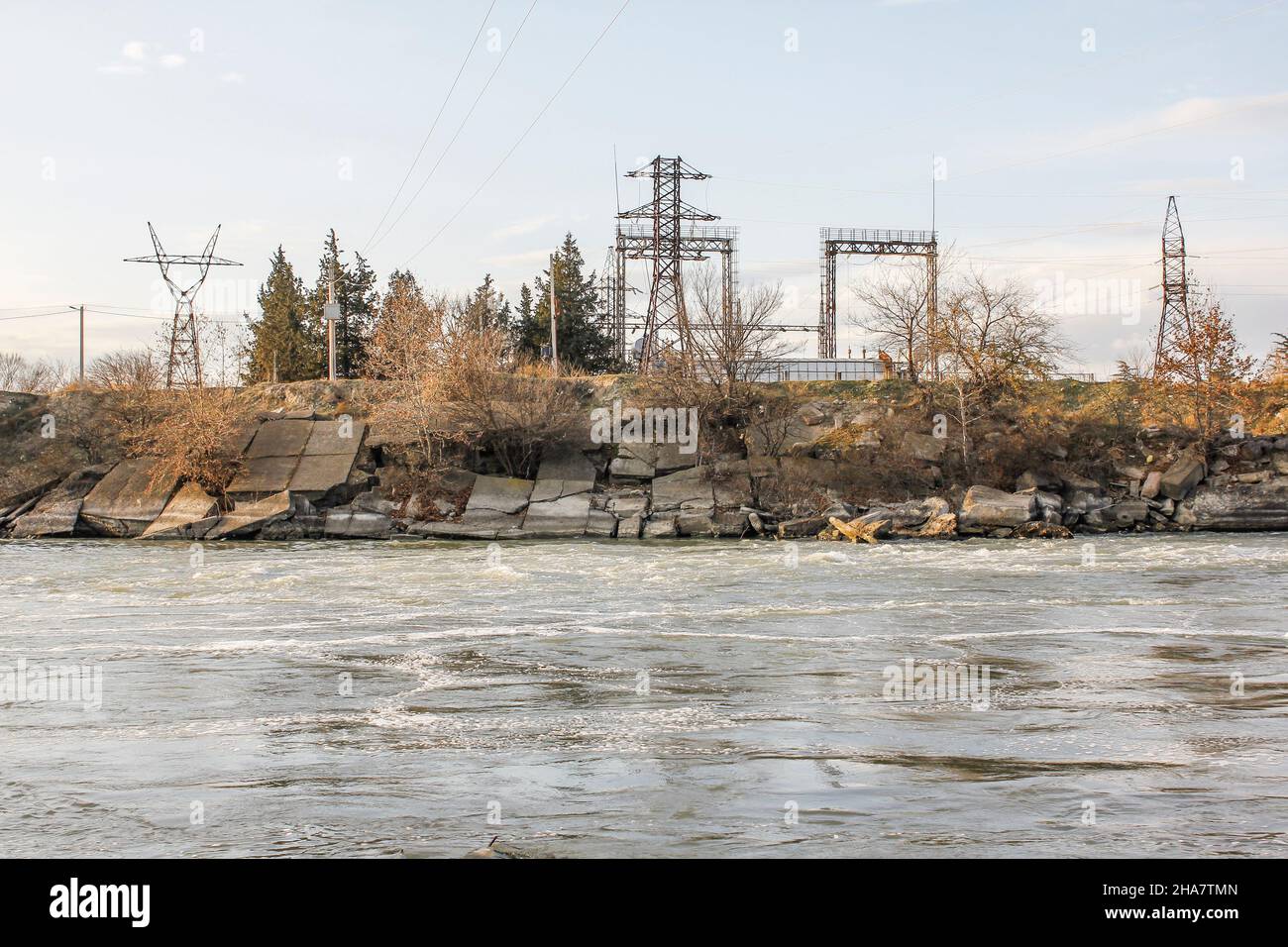 Electricity transmission pylons on the river bank Stock Photo - Alamy