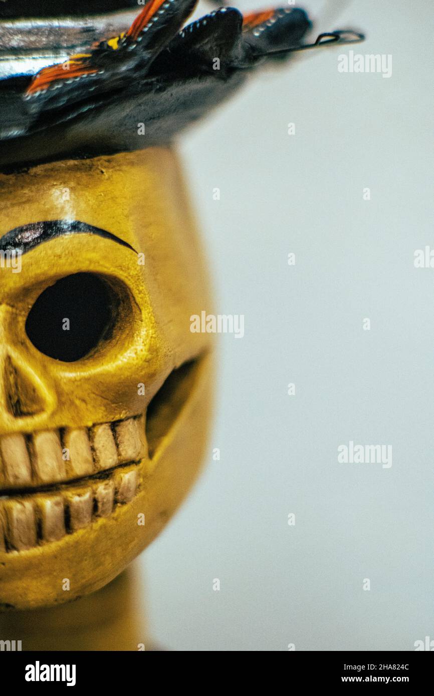 Vertical shot of a scary sculpture of a skull in a hat on a white ...