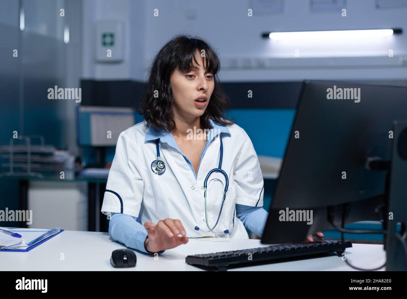Practitioner typing on computer keyboard at office, working late at ...