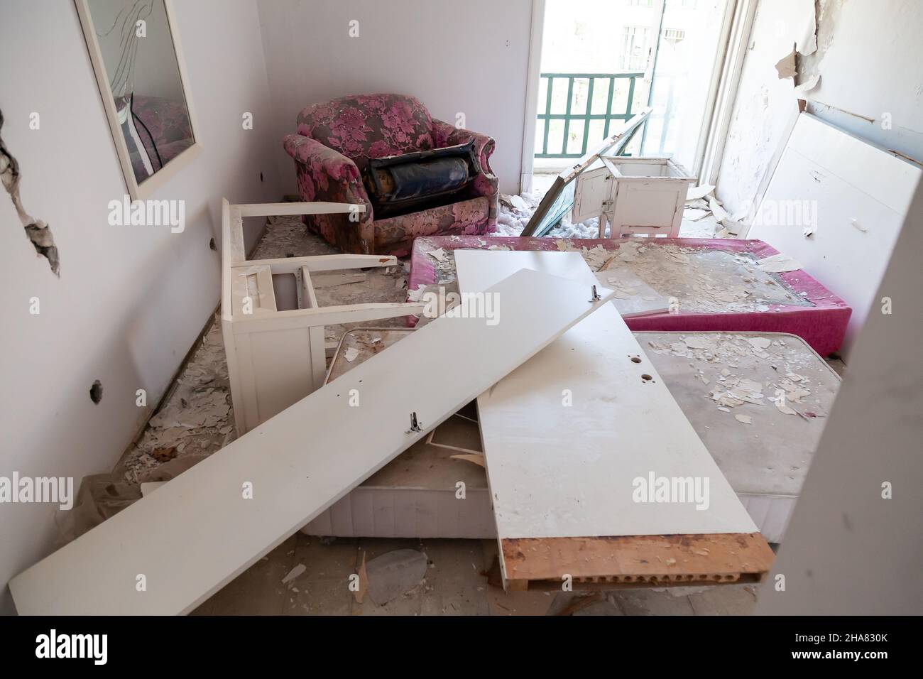 Pieces of broken glass among destroyed furniture and door in an ...