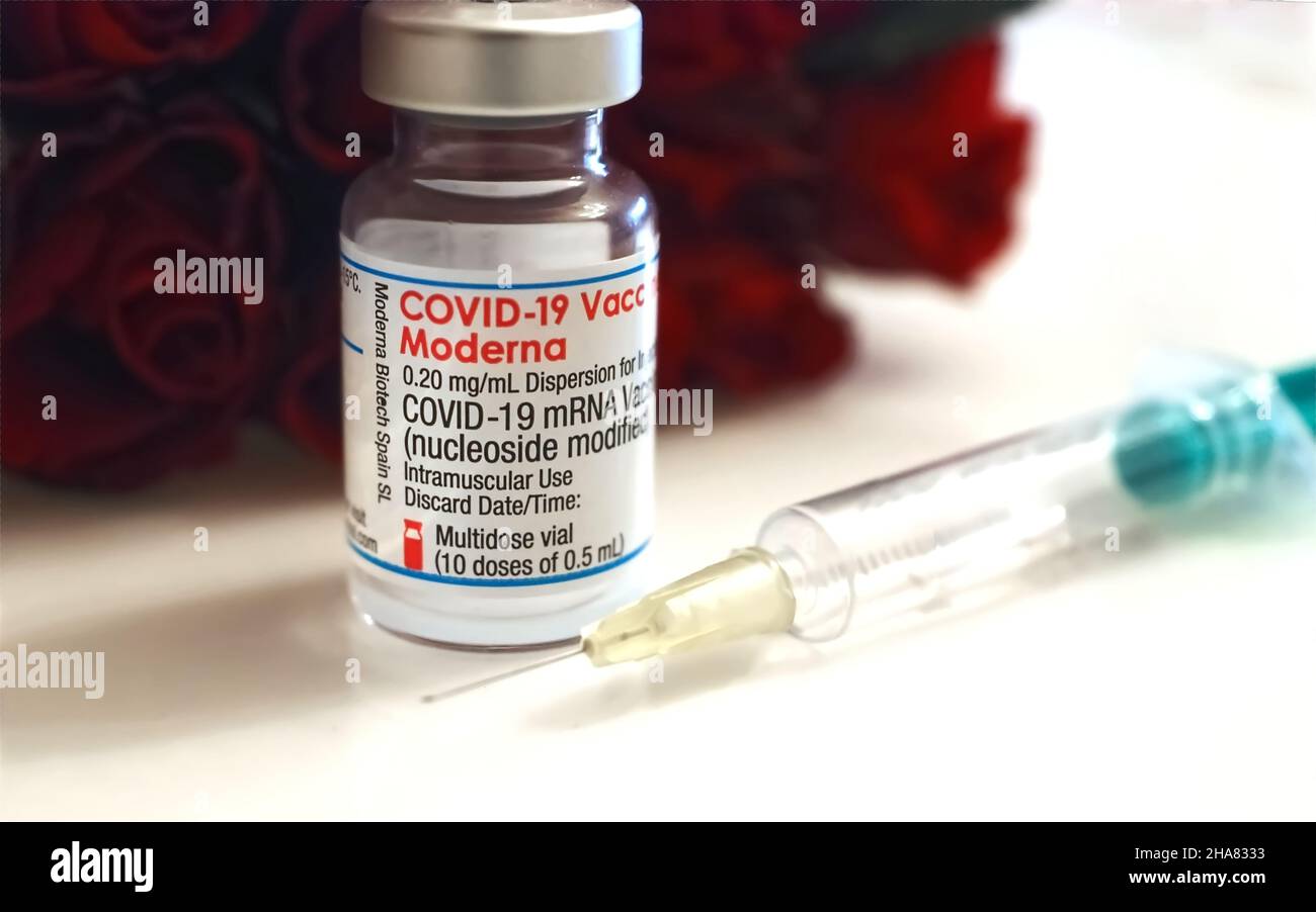 Isolated Moderna spikevax ampoule with a syringe against corona and red ...