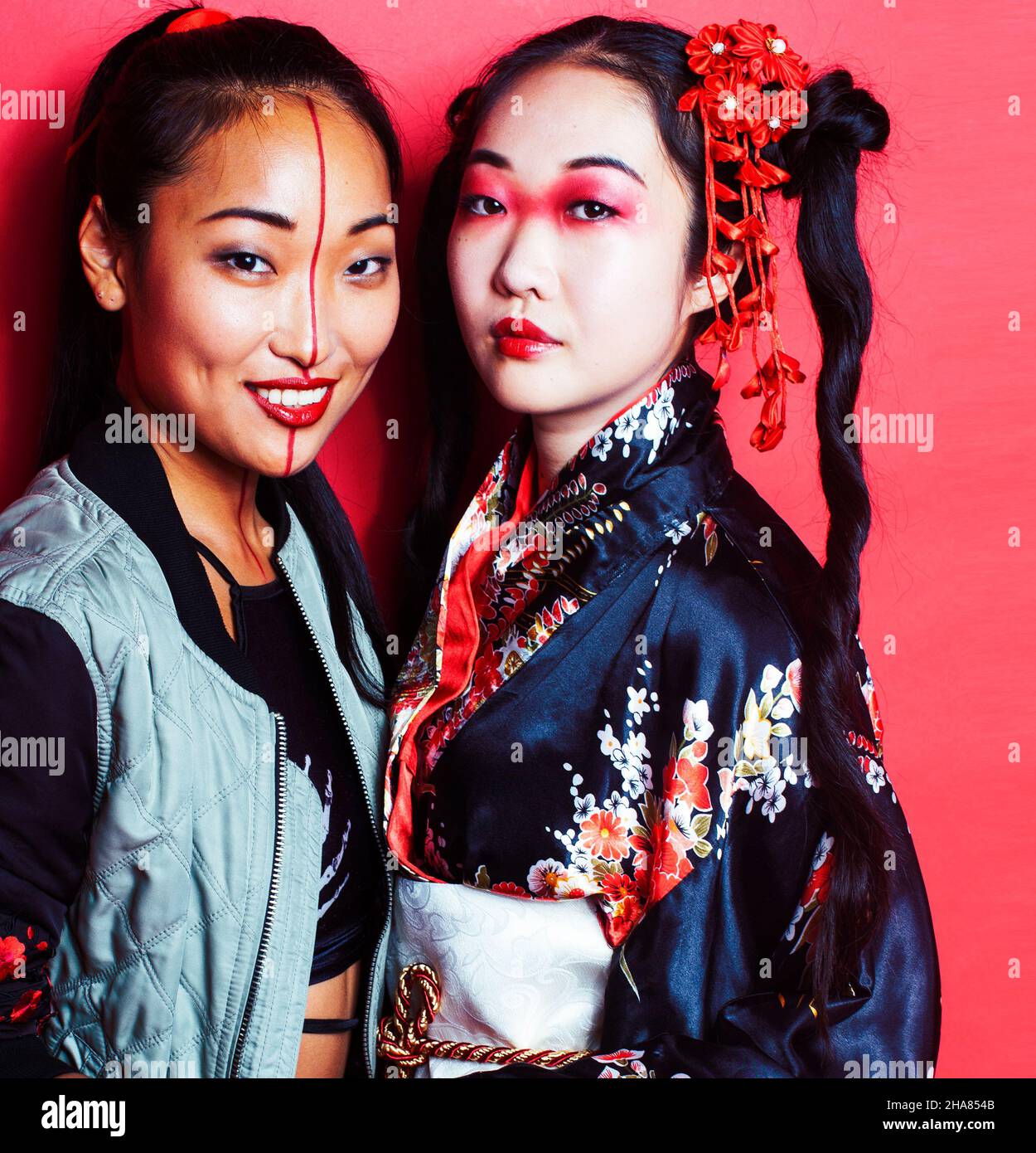 two pretty geisha friends: modern asian woman and traditional wearing ...