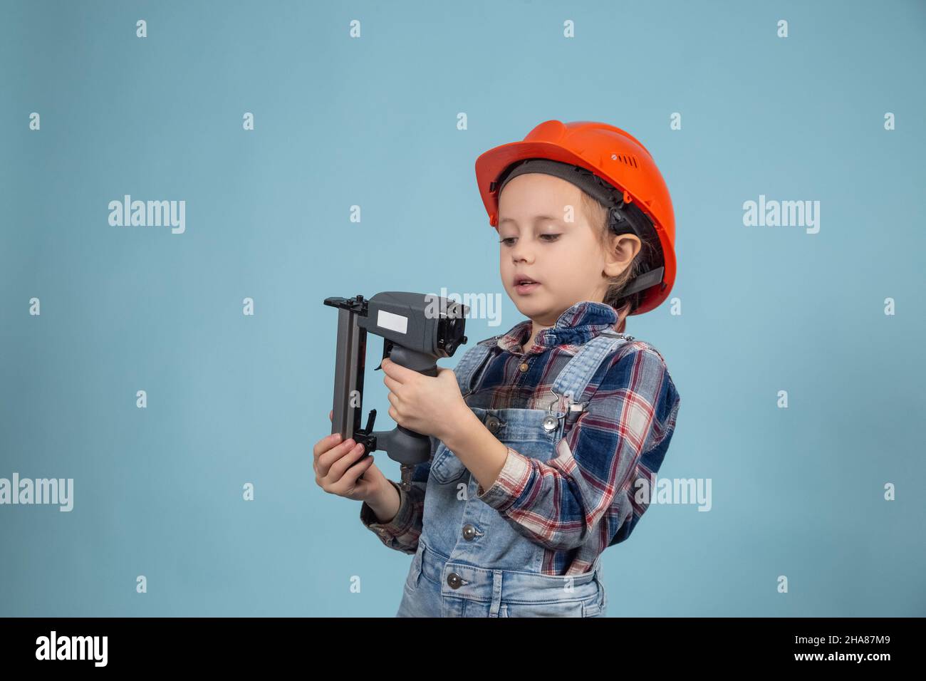 Adorable caucasian child is wearing orange safety helmet,holding ...