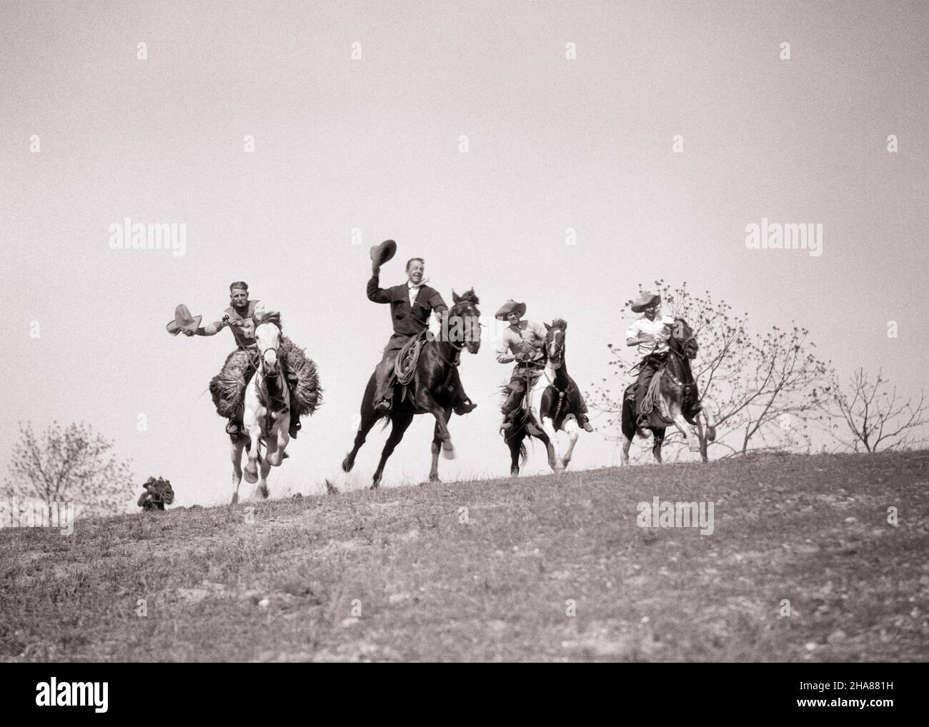 1920s FOUR COWBOYS GALLOPING OVER CREST OF A HILL ENACTING FREDERICK ...