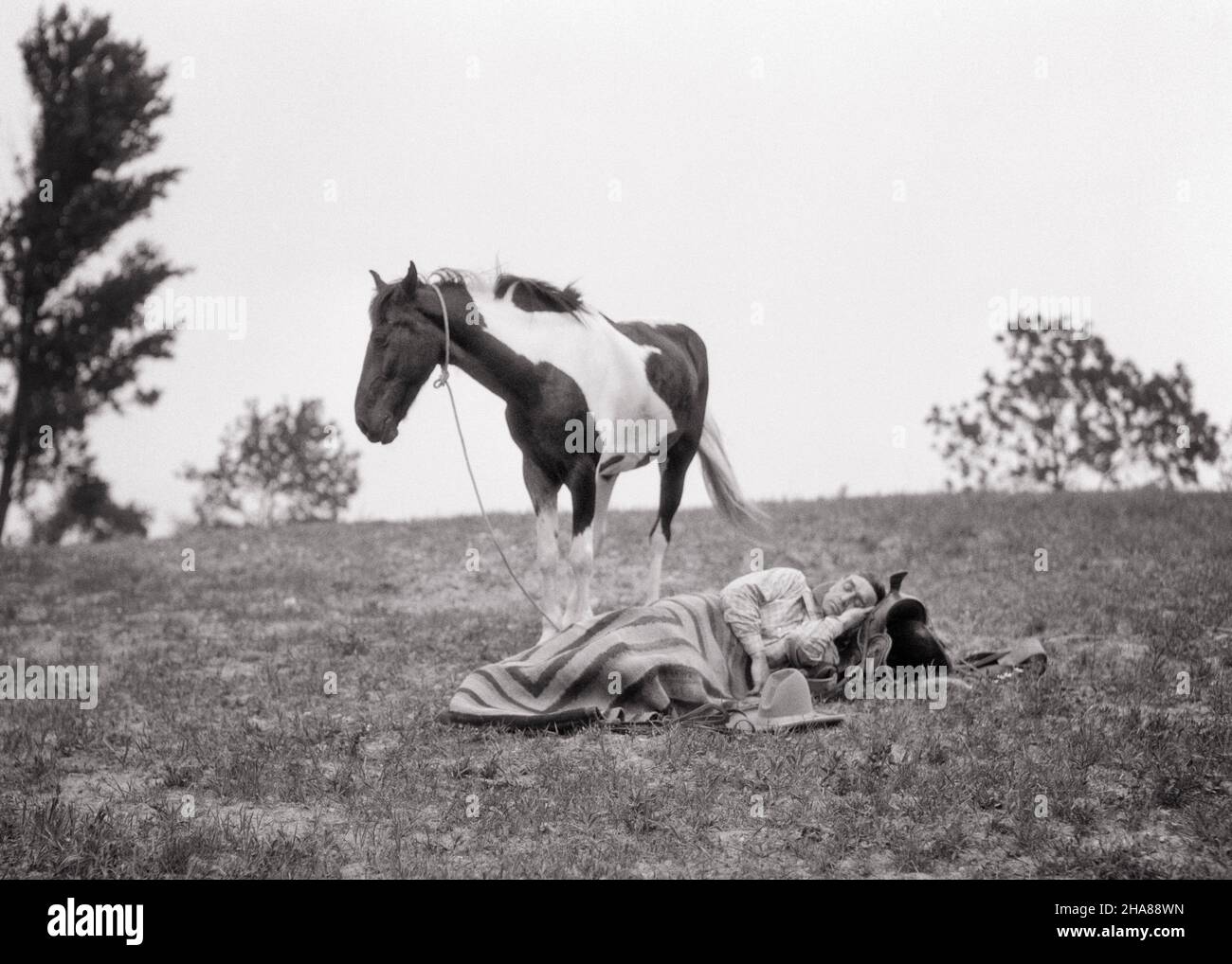 1920s MAN COWBOY HEAD RESTING ON SADDLE SLEEPING OUT ON THE WESTERN ...