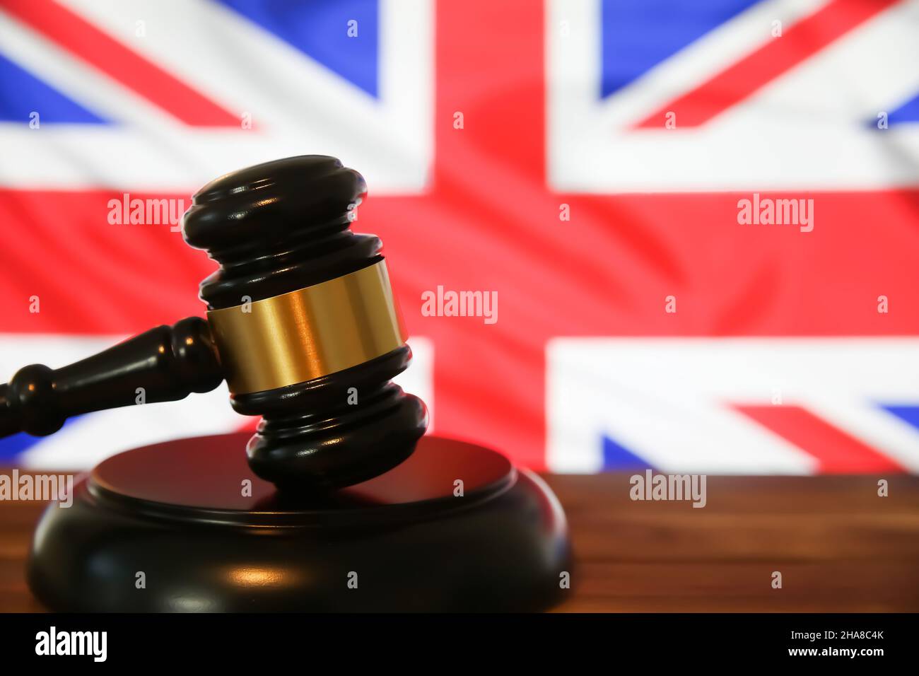 Closeup of isolated judge wood gavel with blurred english flag ...