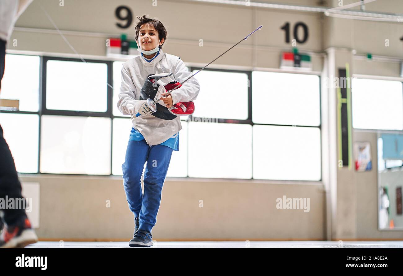 Child finishing fencing indoors in training room Stock Photo - Alamy