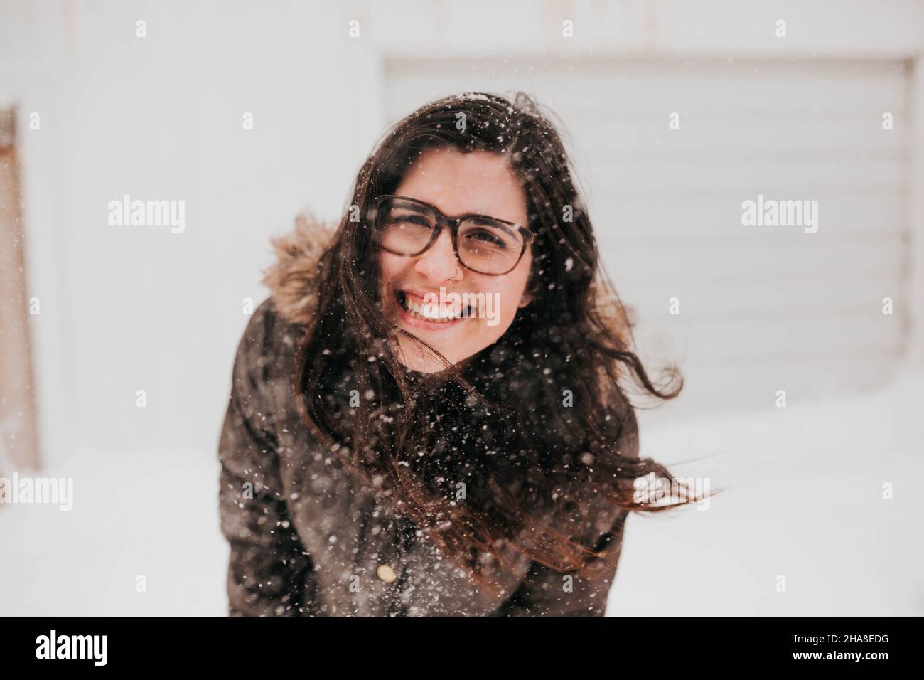 Close up of smiling woman with blowing hair during snow storm Stock ...