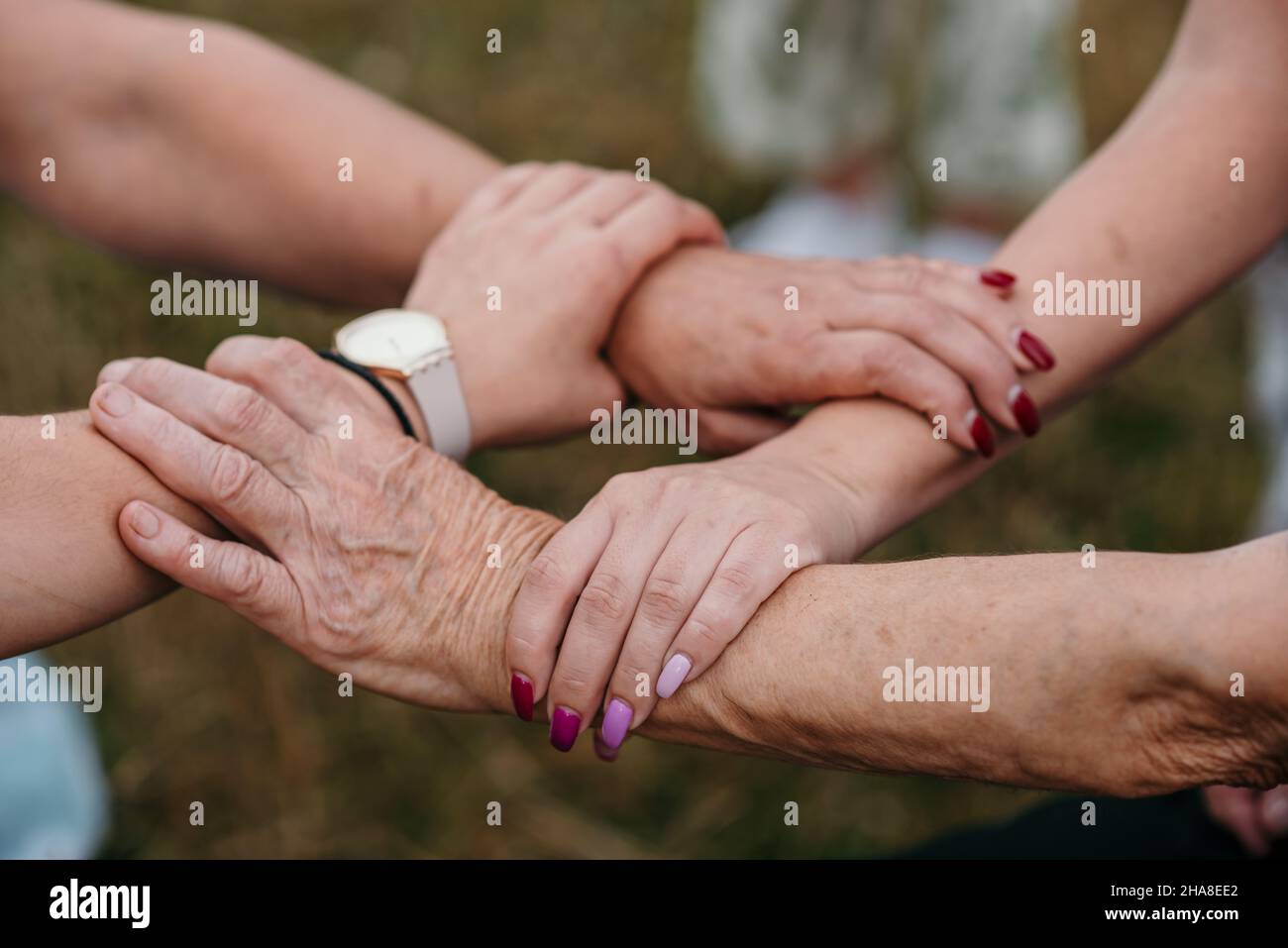 Closeup shot of women's hands from different generations holding each ...