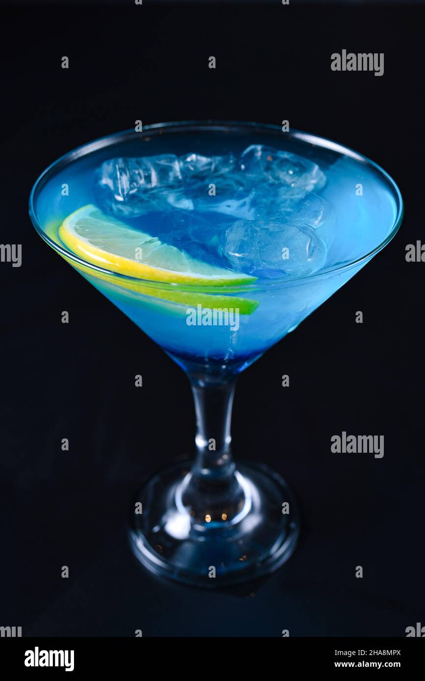 Refreshing citrus cocktail in turquoise color on a dark surface Stock ...