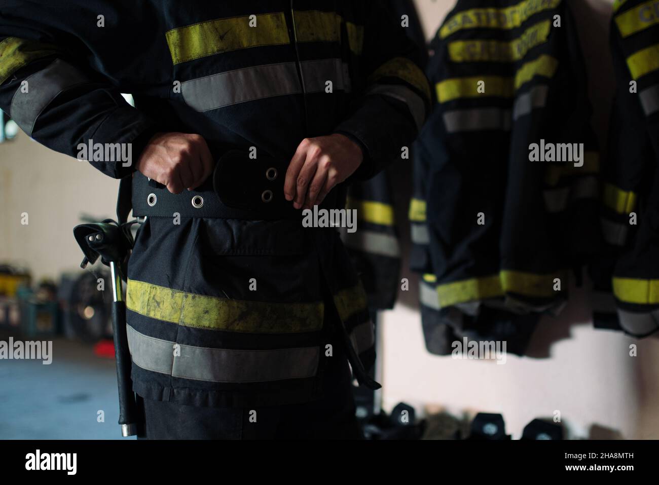 View of a firefighter fixing his belt of a uniform Stock Photo - Alamy