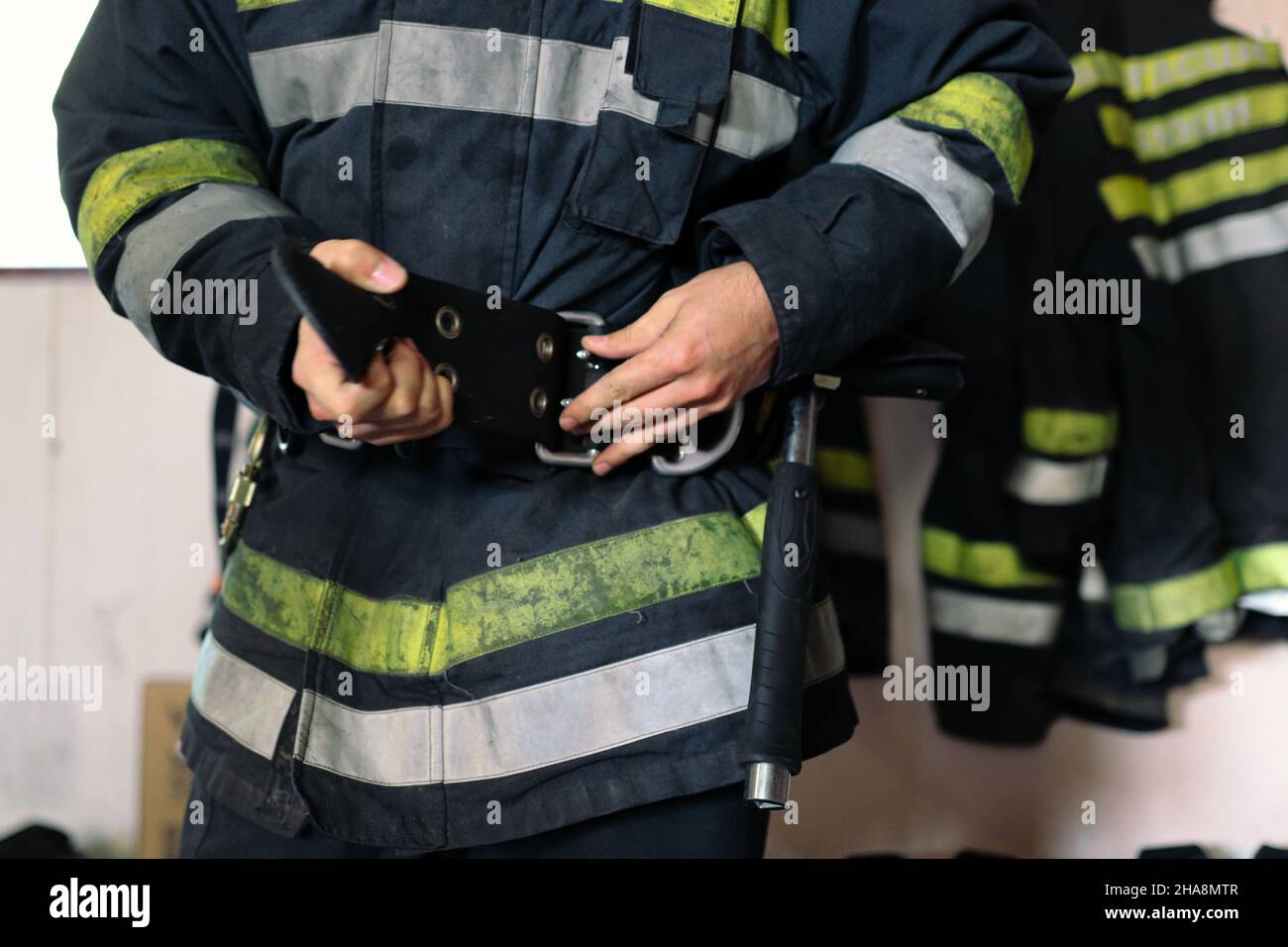 View of a firefighter fixing his belt of a uniform Stock Photo - Alamy