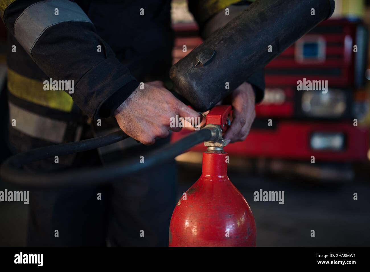 Closeup shot of a firefighter' hands adjusting the fire extinguisher ...