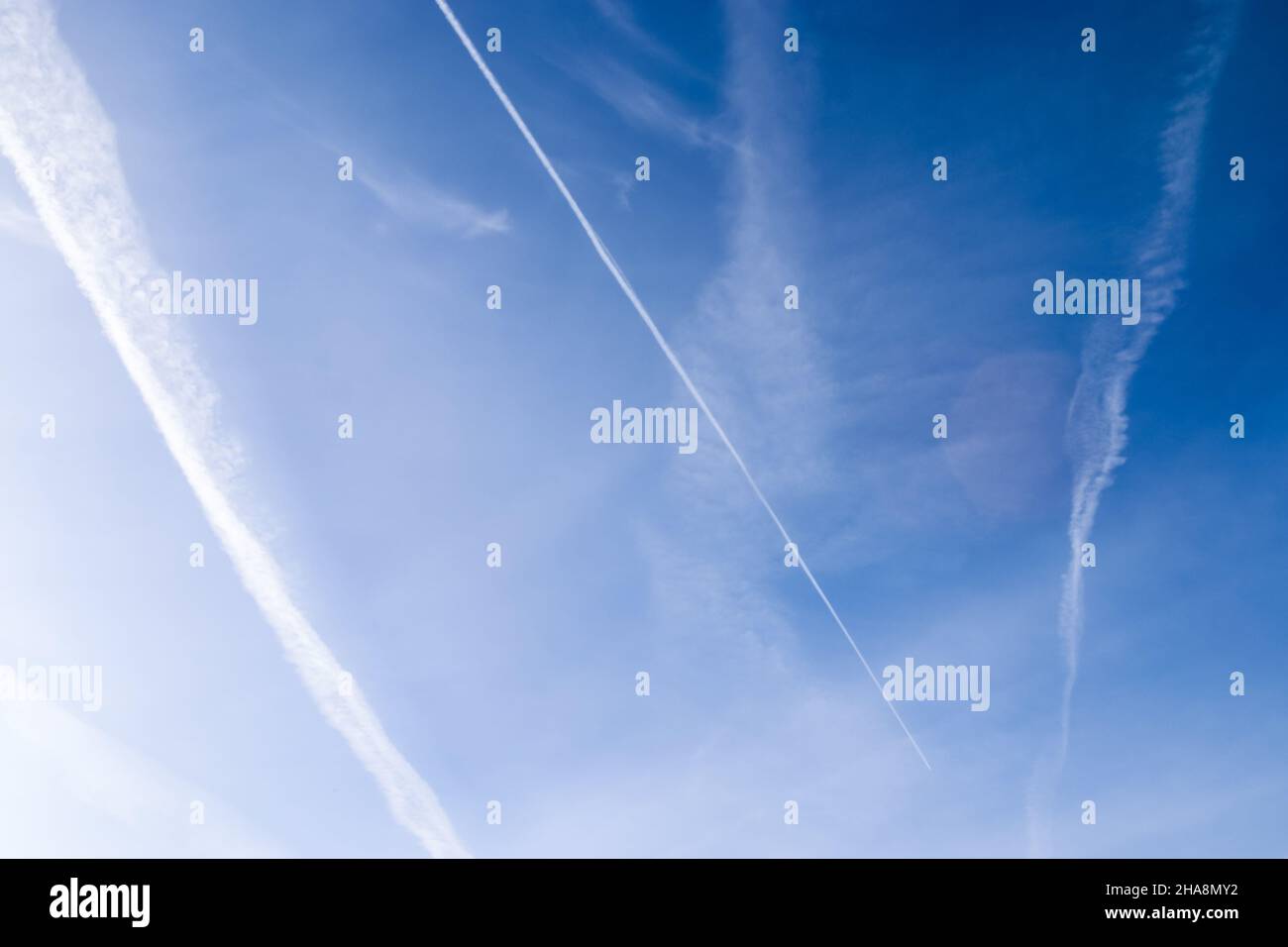 Aircraft condensation contrails in the blue sky inbetween some ...