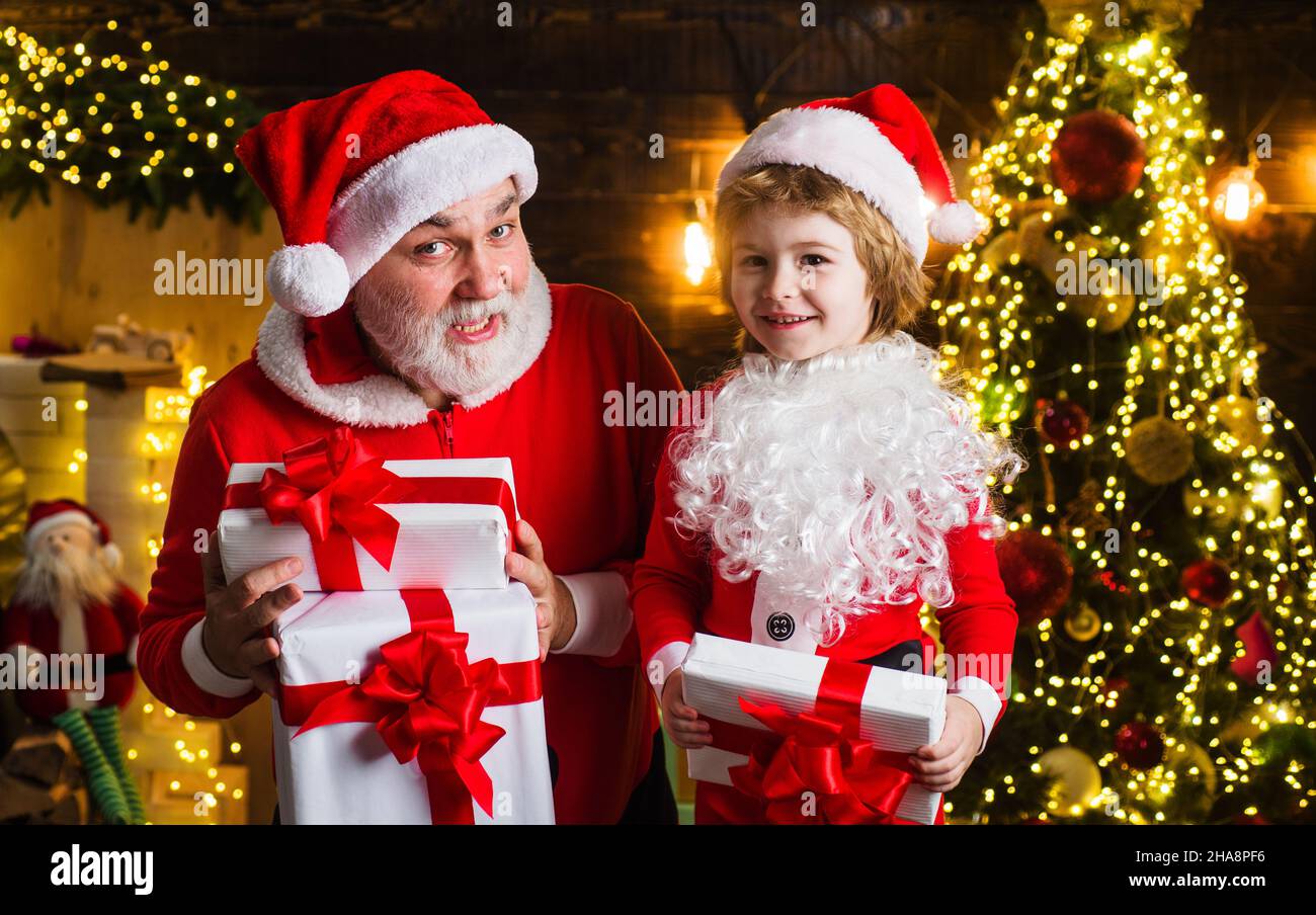 Santa Claus and little helper with Christmas present. New year gift ...