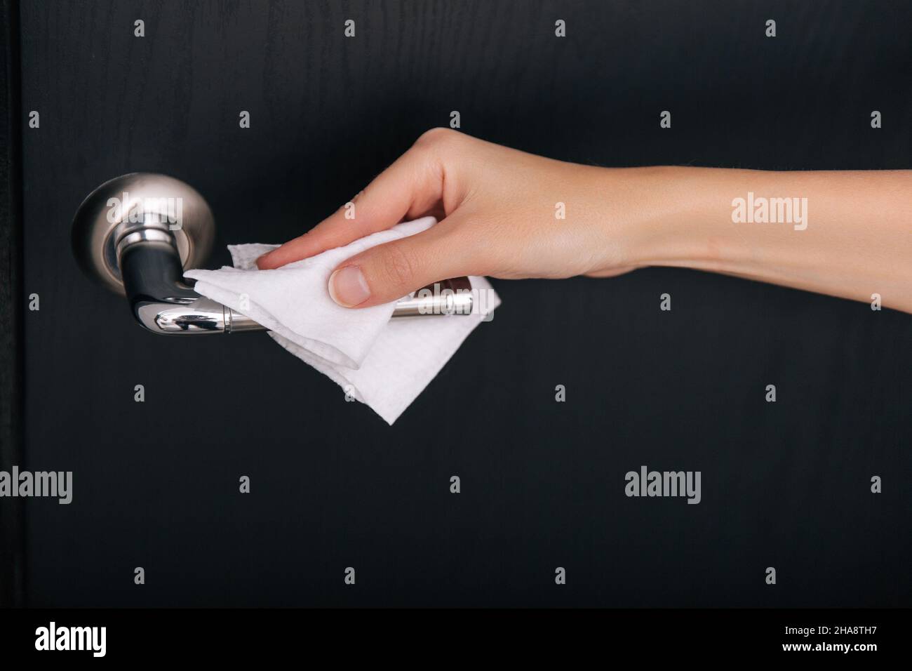 Cleaning black door handles with an antiseptic wet wipe. Sanitize ...