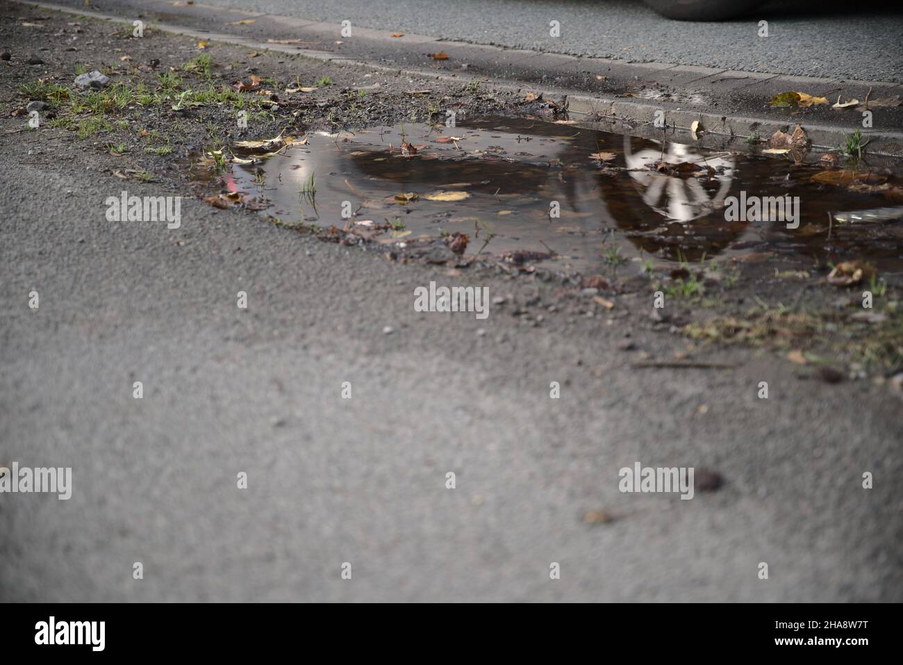 Reflection of a car on a water hole in a street Stock Photo - Alamy