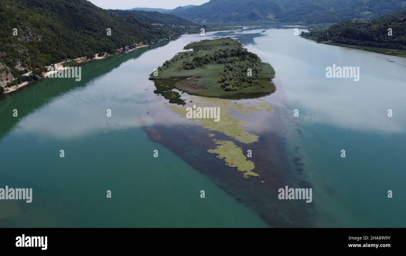 Scenic view of a blue ocean surrounded by mountains on a clear sky ...