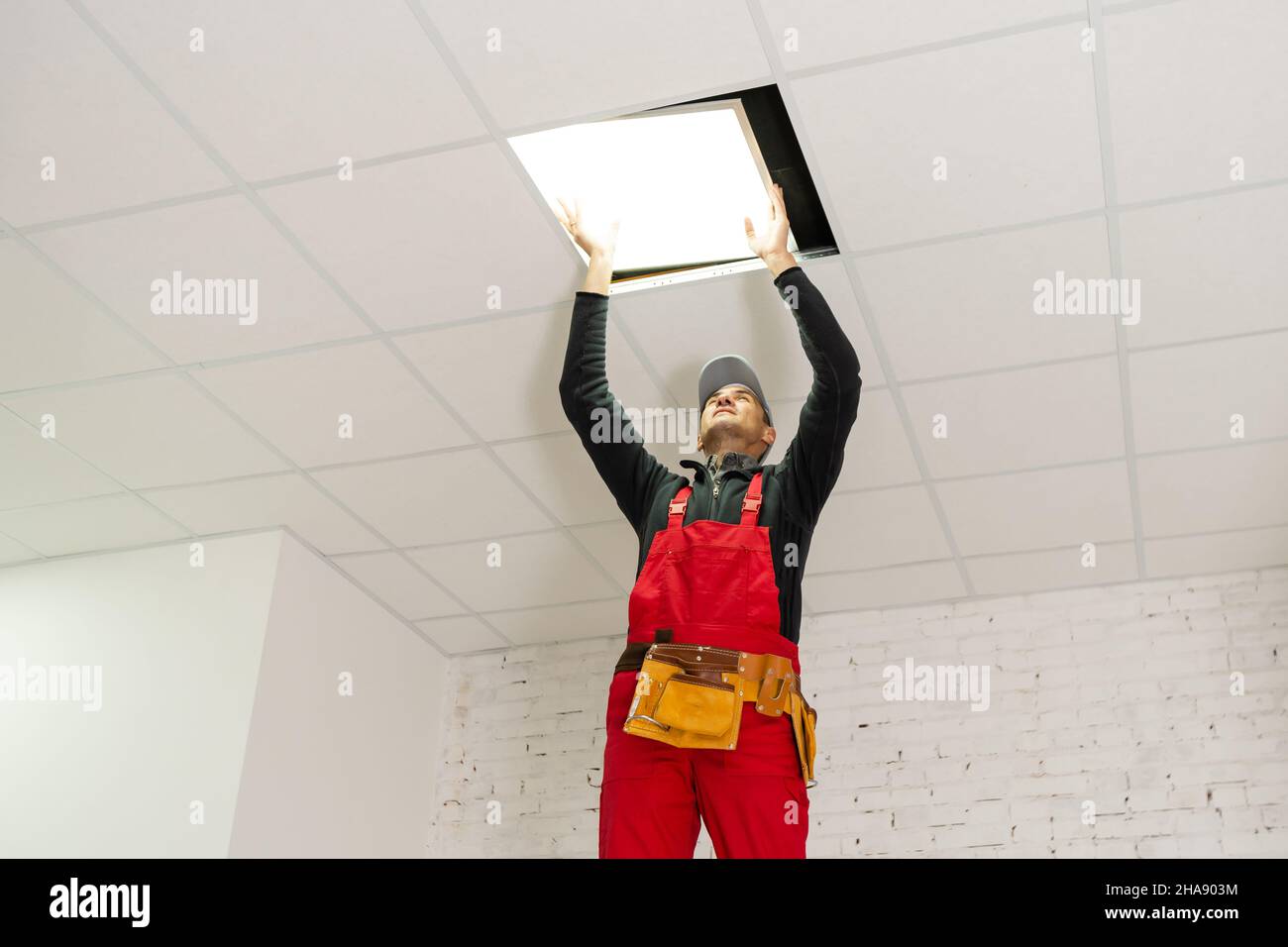 Builder replacing ceiling panel, working, ceiling armstrong Stock Photo ...