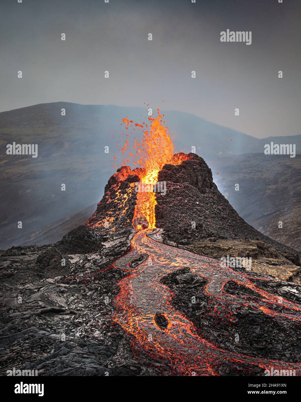 Beautiful shot of an active volcano with flowing lava and smoke under a ...