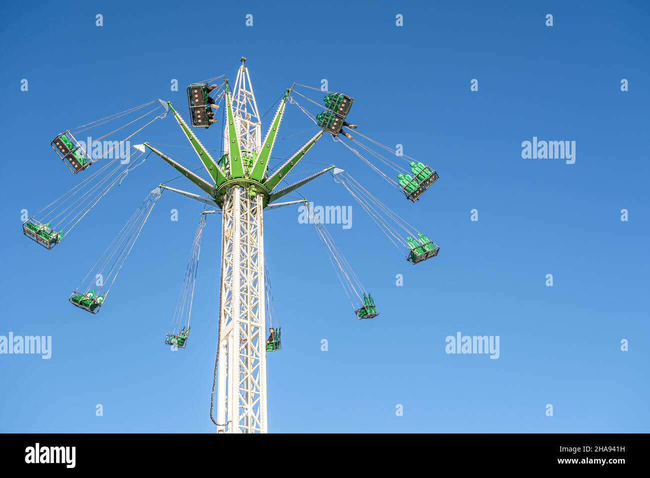Flying swing carousel in action with empty seats at an amusement park ...