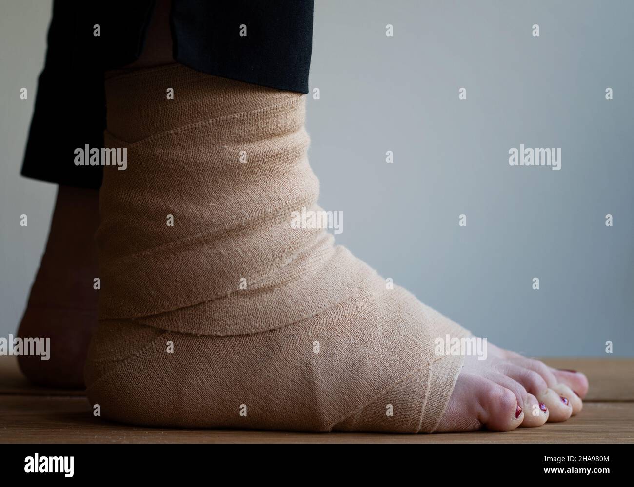 Close up of a person with a compression bandage wrapped around the foot ...