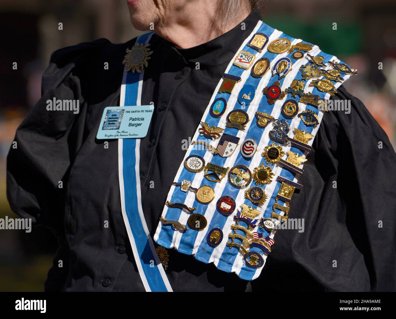 A member of the Daughters of the American Revolution wears her DAR pins ...