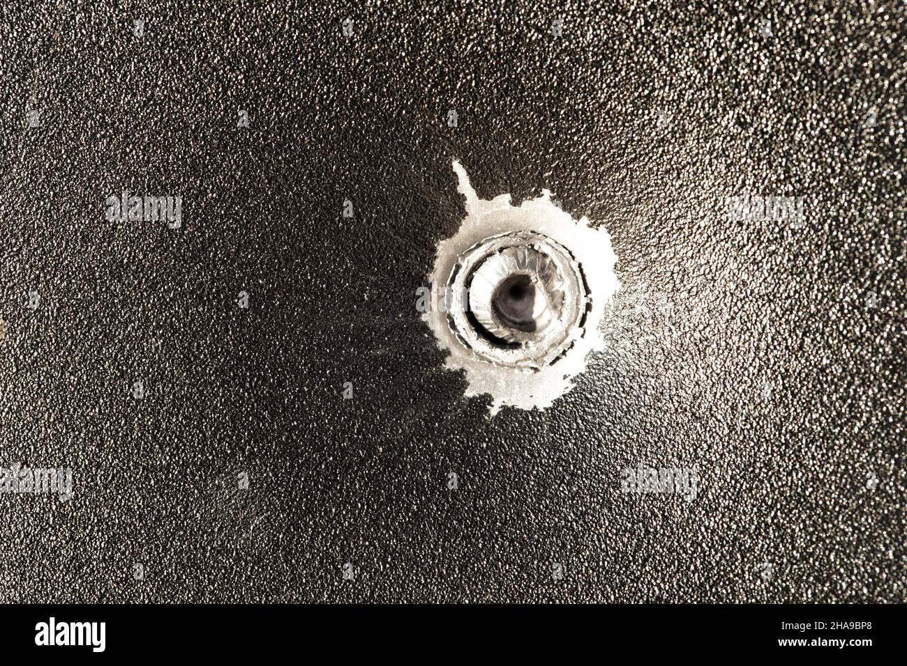 The lead bullet is stuck in a metal armor plate or a piece of sheet ...