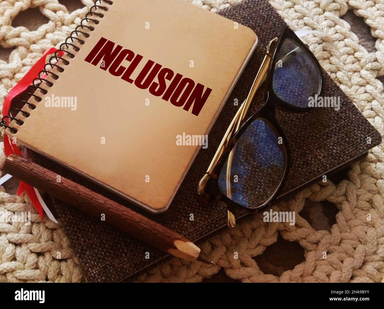 Book with text inclusion, glasses and pen on beautiful crochet carpet ...