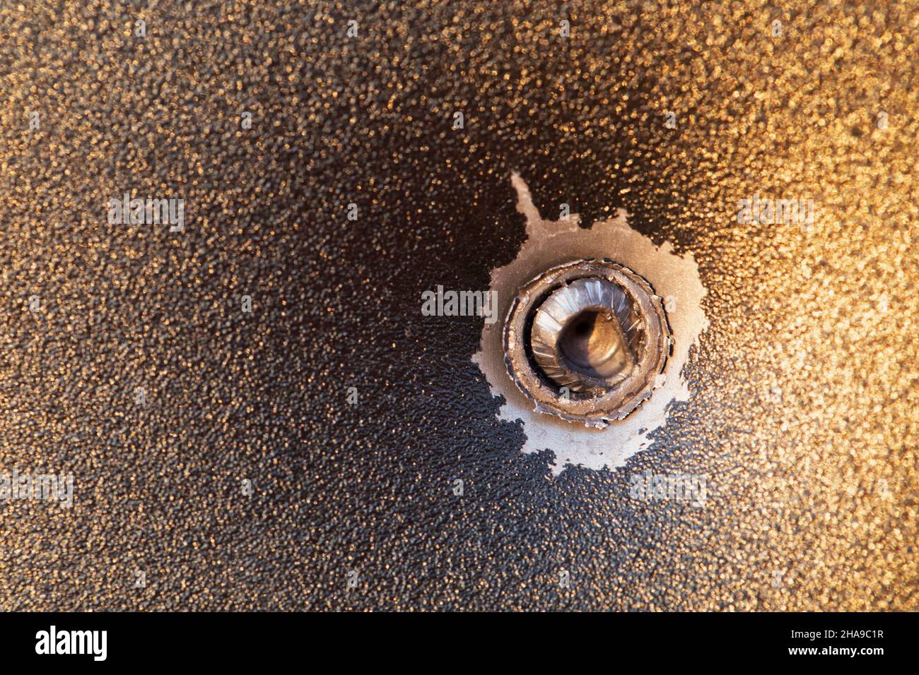 The lead bullet is stuck in a metal armor plate or a piece of sheet ...