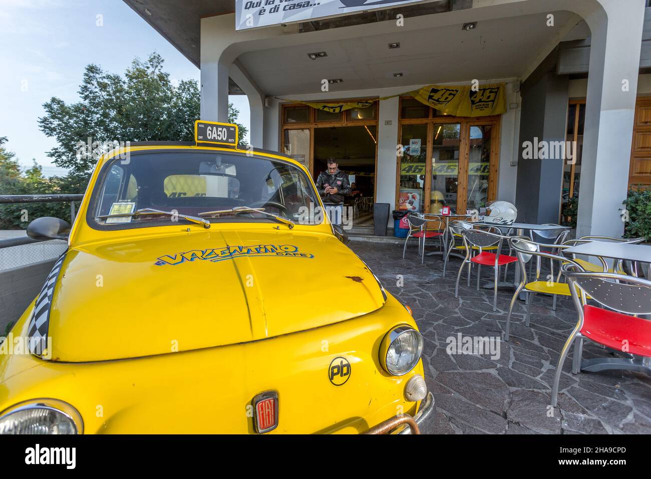 TAVULLIA, ITALY - Sep 18, 2013: A cafe terrace with a parked yellow ...