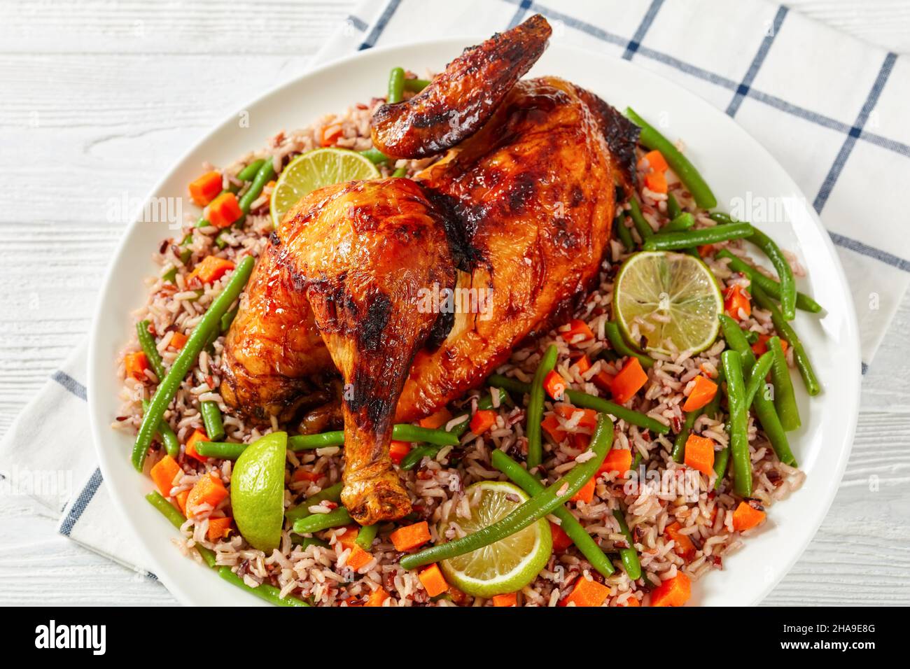 Grilled Half Chicken with Veggie Fried brown and wild Rice on a white ...
