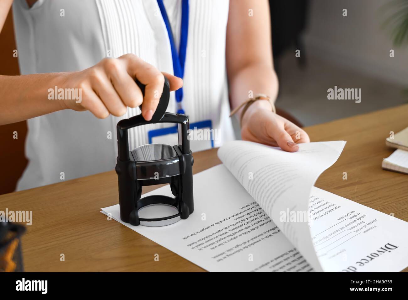 Female notary public attaching seal to document in office, closeup ...