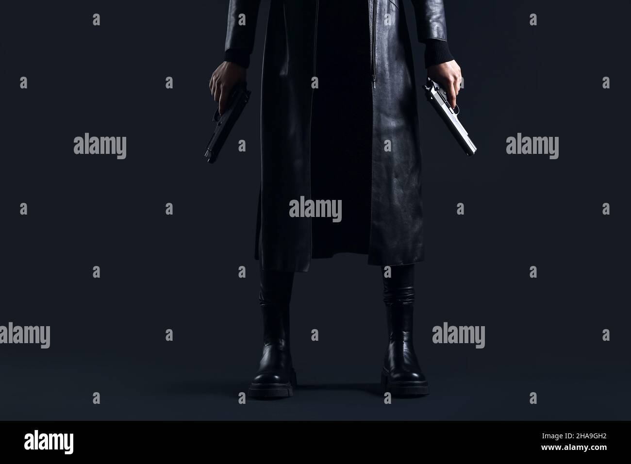 Woman with guns dressed in matrix style on dark background Stock Photo ...