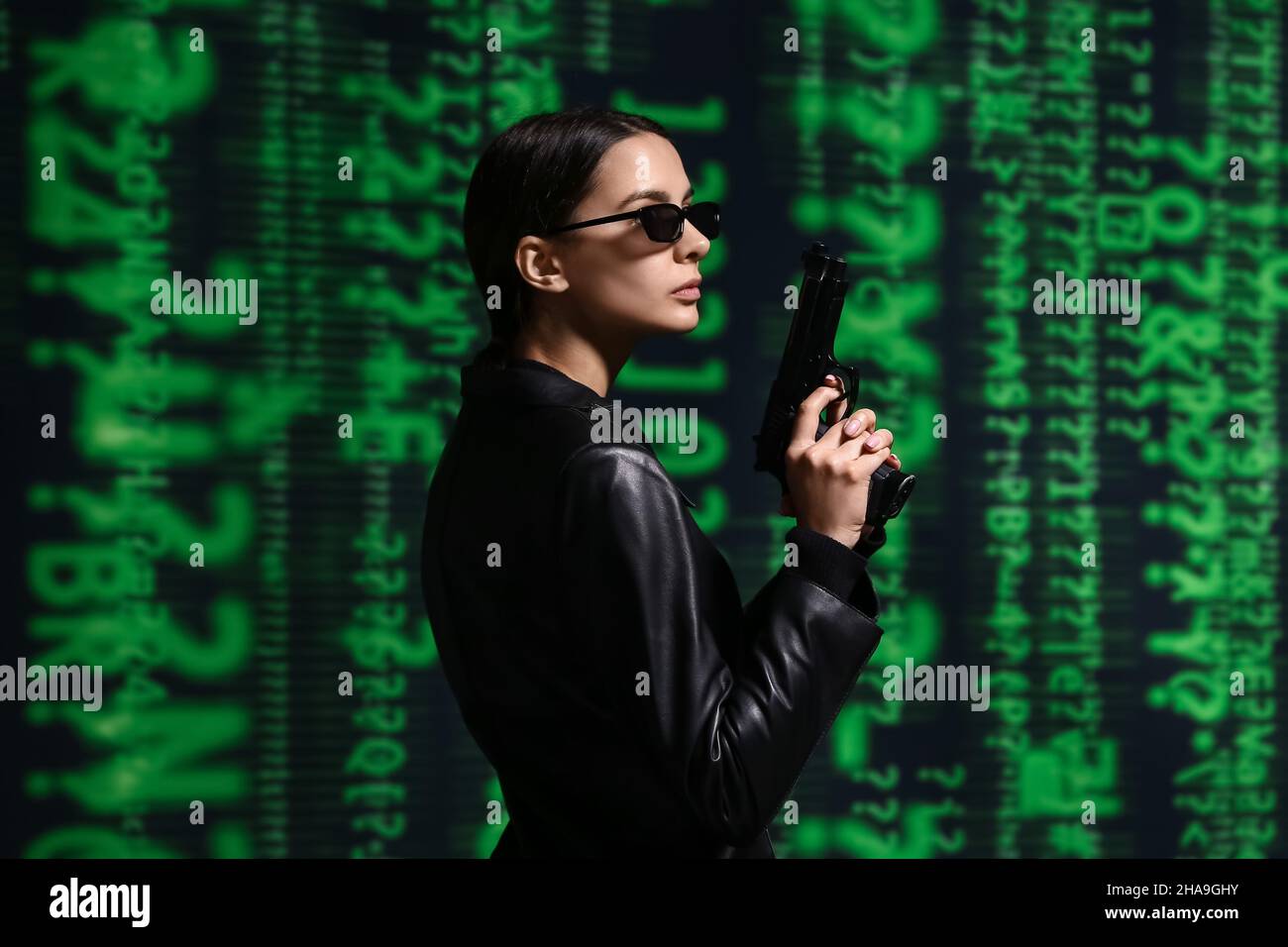 Woman with gun dressed in matrix style on dark background Stock Photo ...