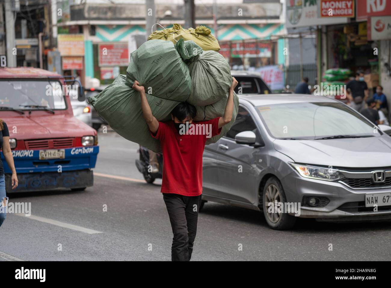 A man carrying a heavy load balanced above his head, Cebu City ...