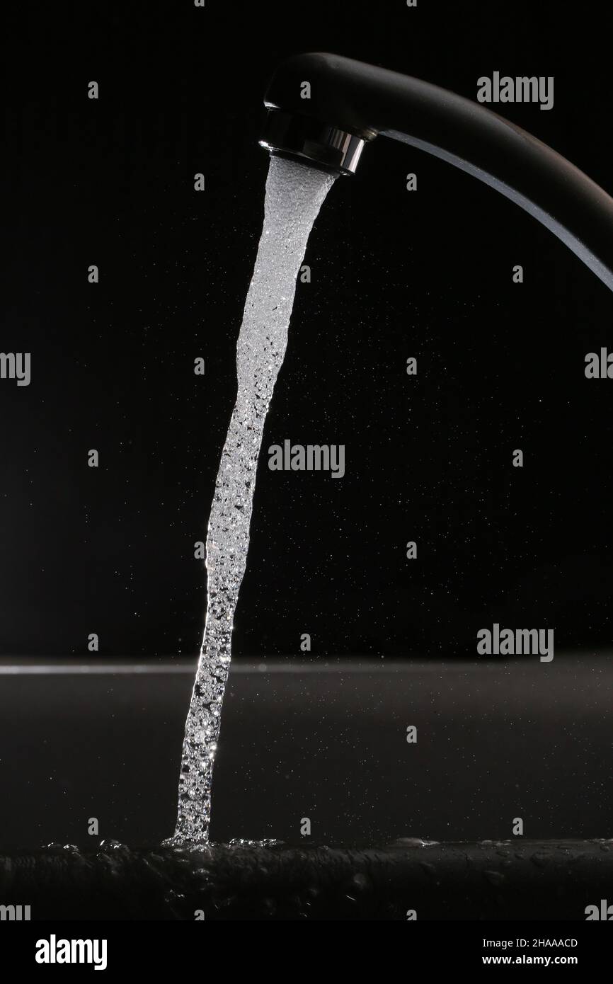 Failure of pure tap water on a black background Stock Photo - Alamy