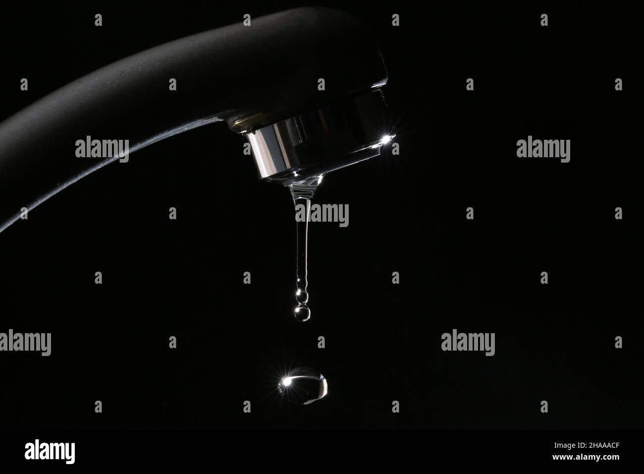 Failure of pure tap water on a black background Stock Photo - Alamy