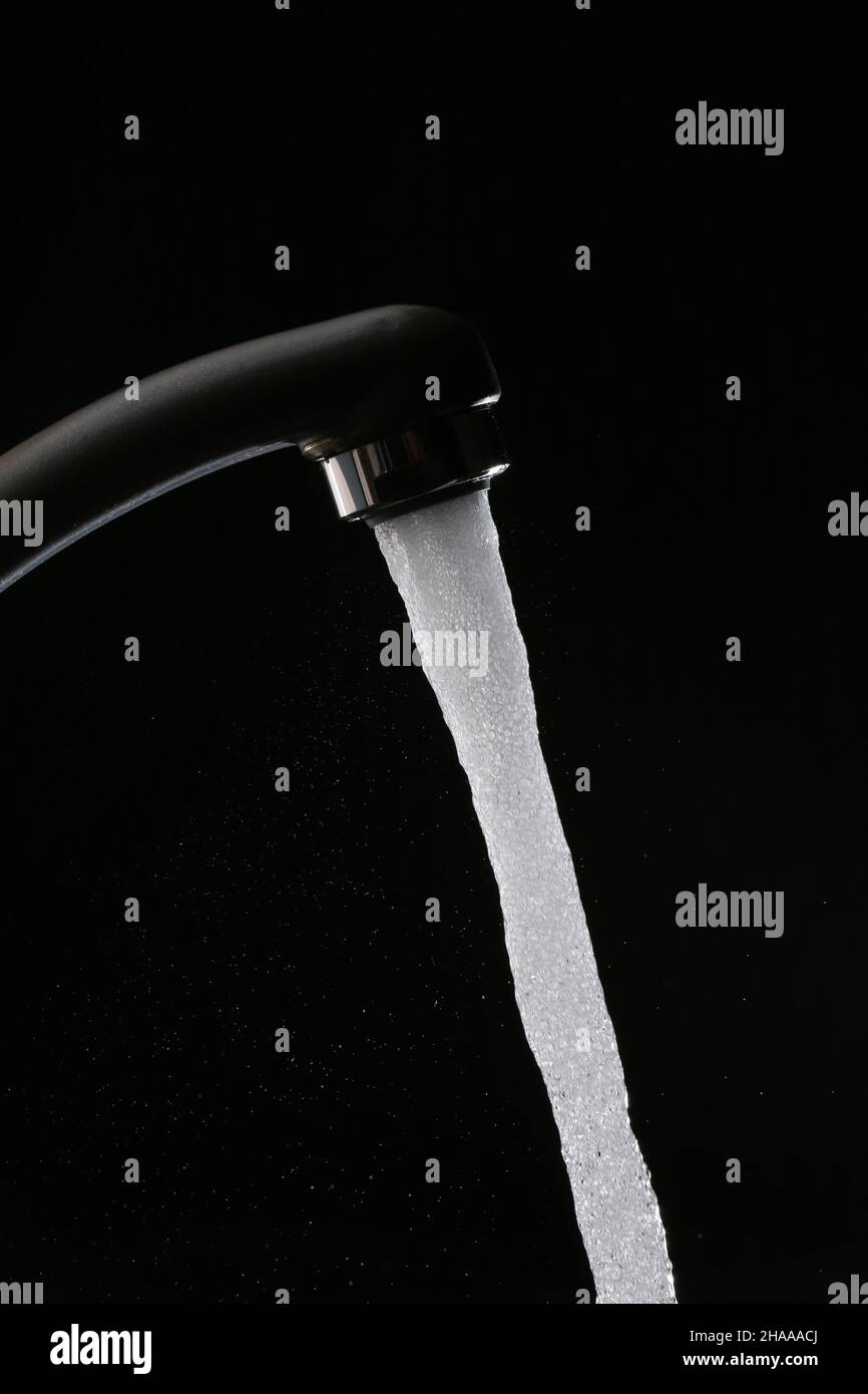 Failure of pure tap water on a black background Stock Photo - Alamy