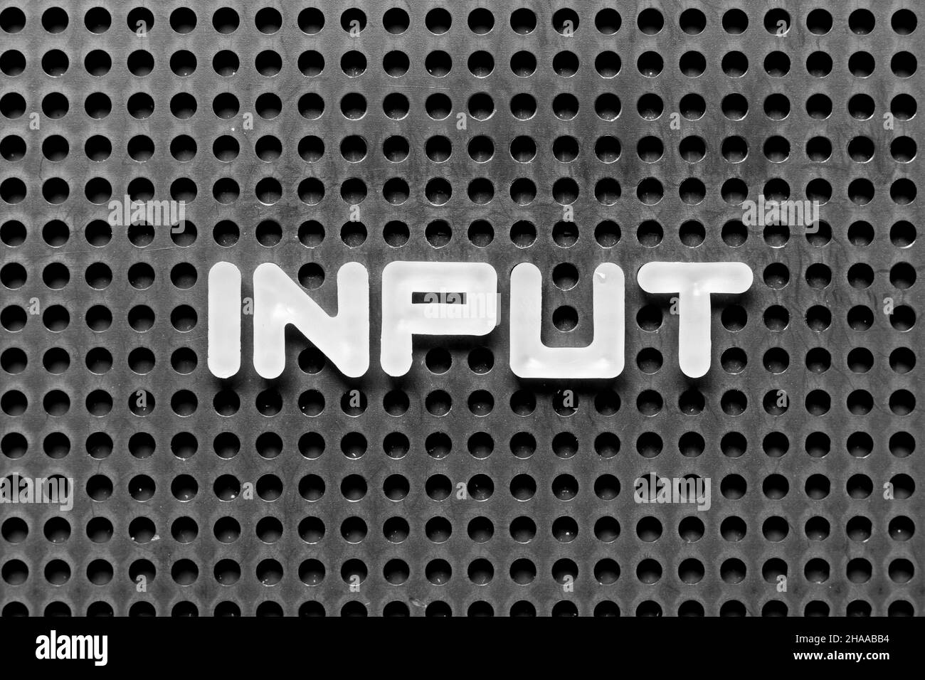 White alphabet letter in word input on black pegboard background Stock ...