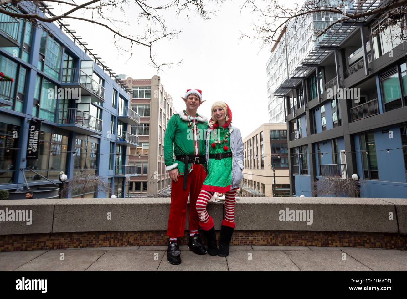 A young couple dressed as elves poses for a photo at the Harbor Steps ...