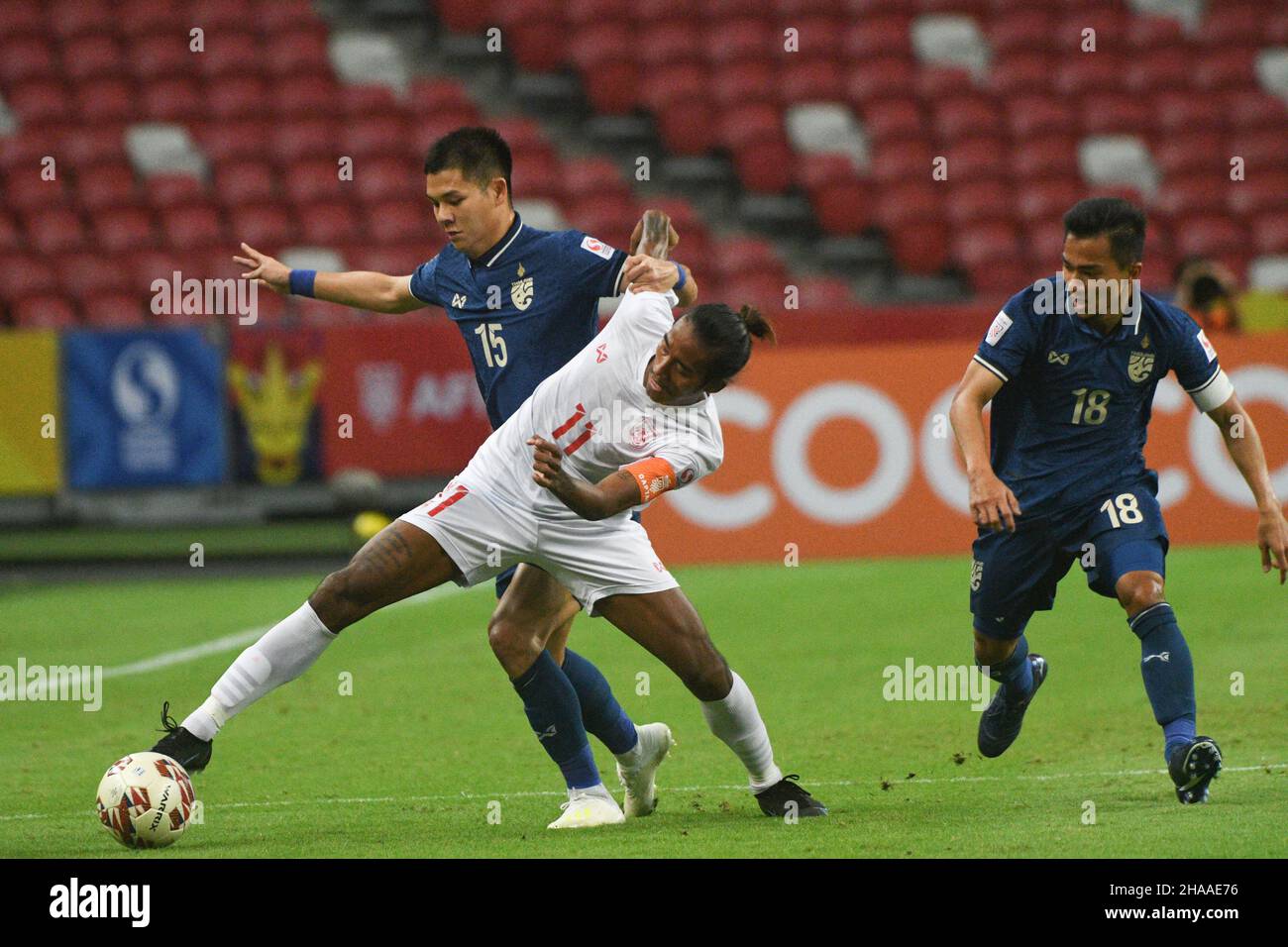 Singapore. 11th Dec, 2021. Maung Maung Lwin (C) of Myanmar fights for the ball with Narubadin ...