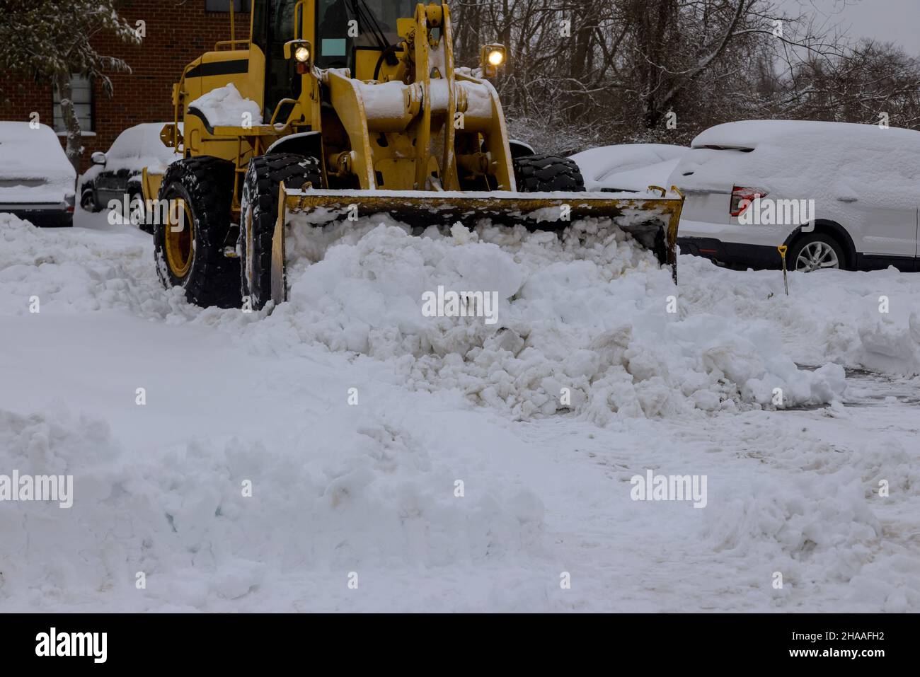 Tractor removing snow on street after snowfall Stock Photo - Alamy