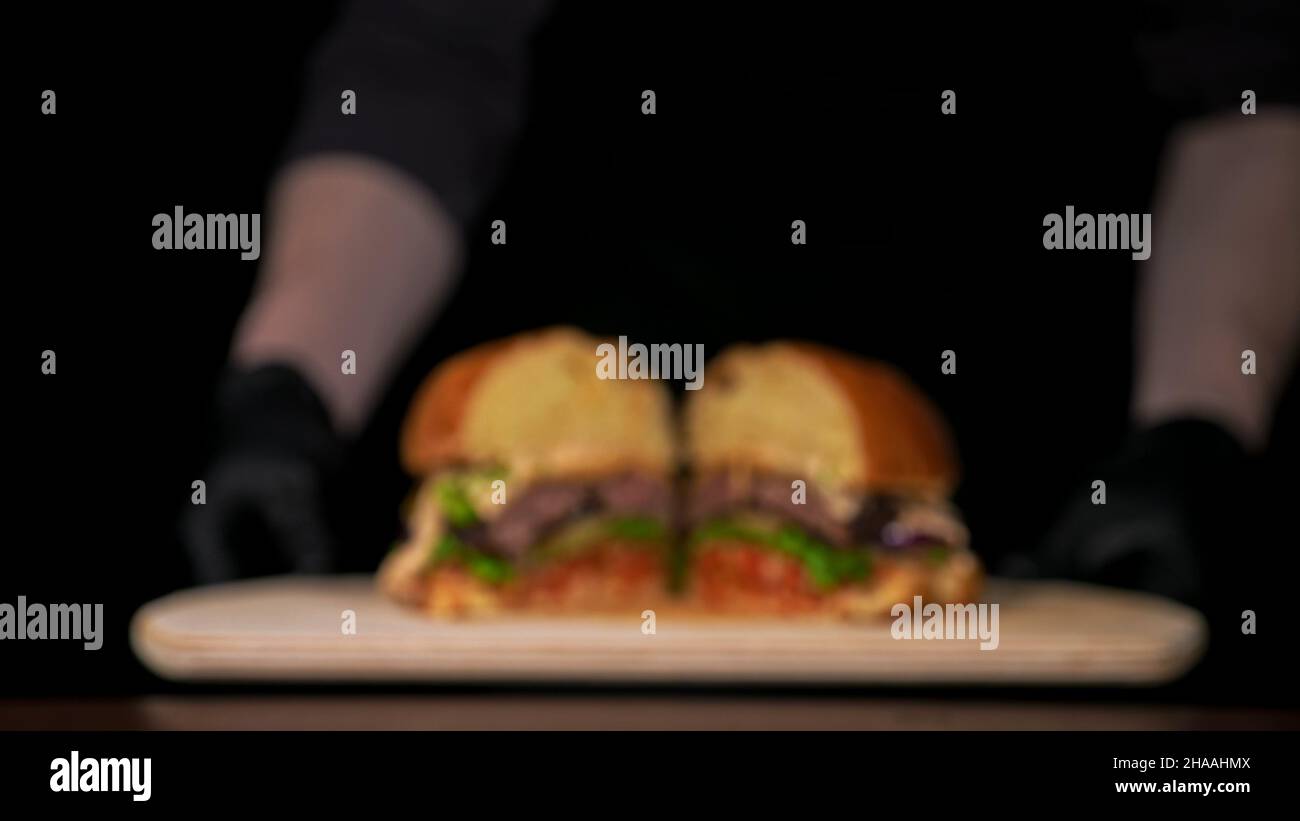 Blur background. Cut craft burger is cooking. Consist: red sauce salsa ...