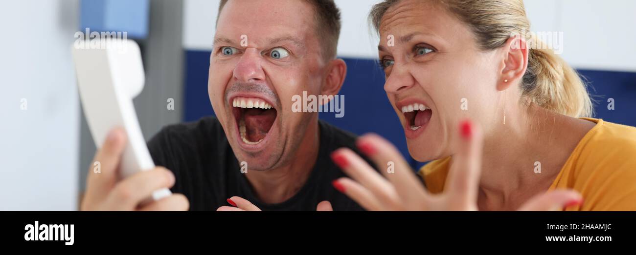 Man and woman shouting into telephone receiver in hotel room Stock ...