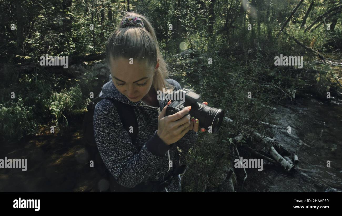 Traveler photographing scenic view in forest river. Wood bridge fallen ...