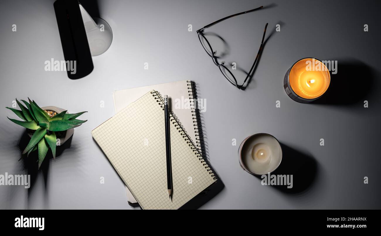 Flat lay, notepad and lamp, workplace at night Stock Photo - Alamy