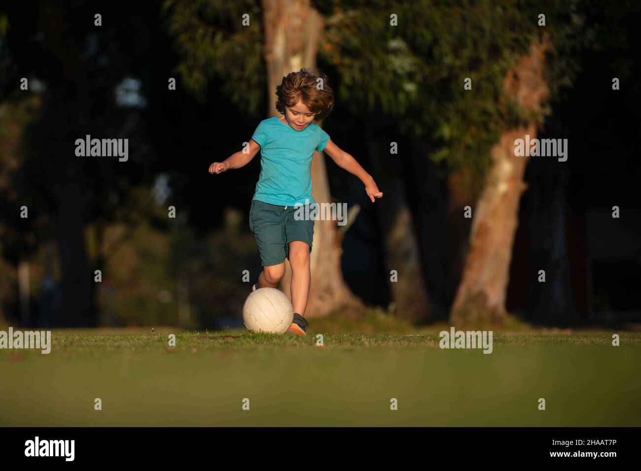 Soccer kid. Kids play football on outdoor stadium field. Little boy ...